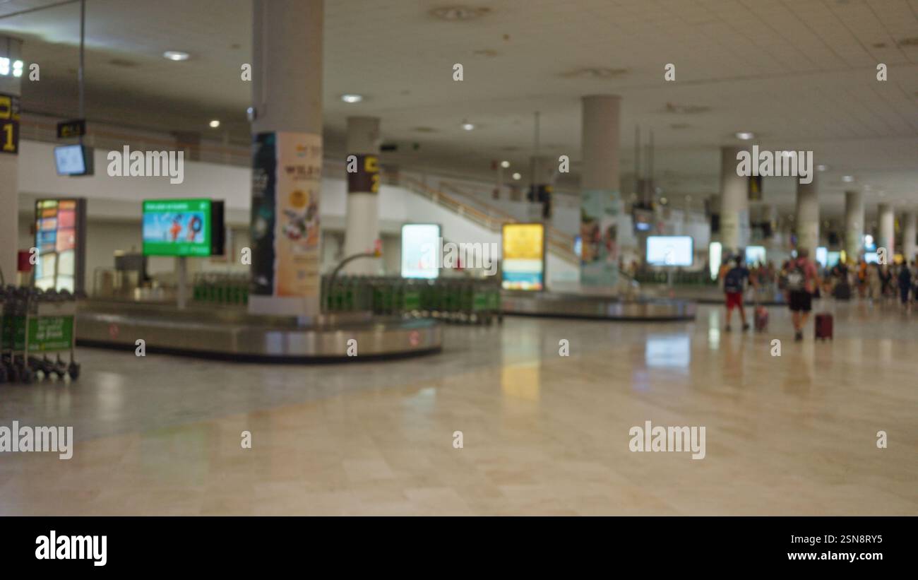 Blurred image of people walking through an airport terminal with ...
