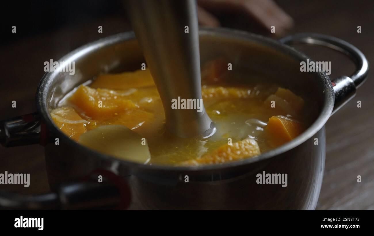 Cooking pumpkin soup. Blending with a blender Stock Photo - Alamy