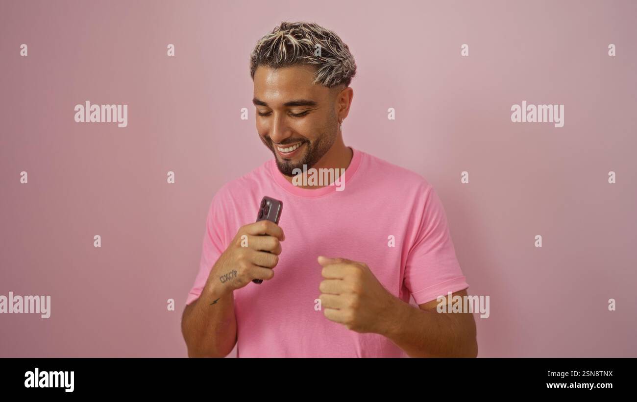 Handsome young arab man dancing joyfully over an isolated pink ...
