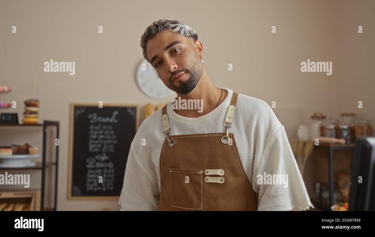 Handsome young arab man with a beard in a bakery shop, standing indoors ...
