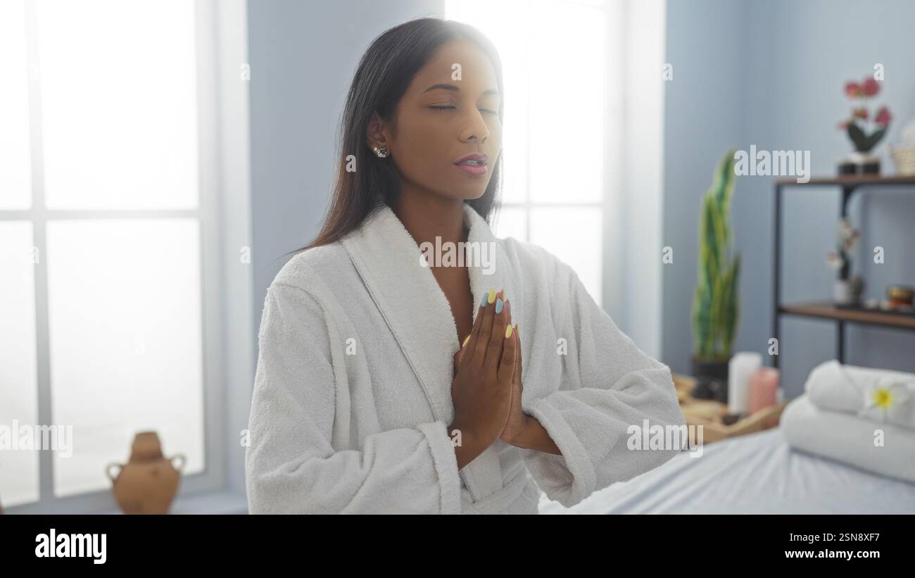 Woman relaxing in spa room wearing white robe with closed eyes and ...
