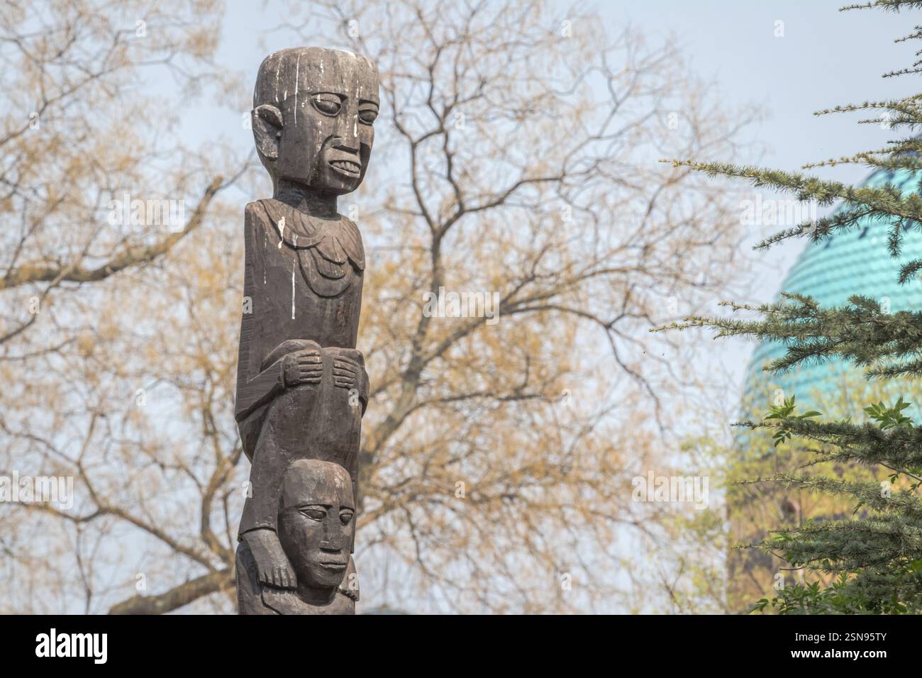A handcrafted wooden totem pole featuring two carved tribal figures ...
