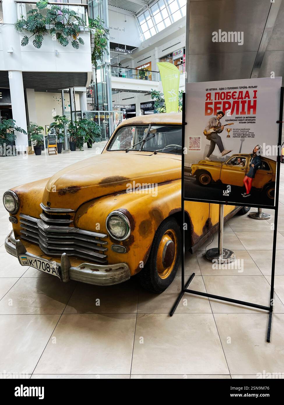 Lviv, Ukraine - February 12, 2025: Yellow classic GAZ-M20 Pobeda car showcased indoors with a ...
