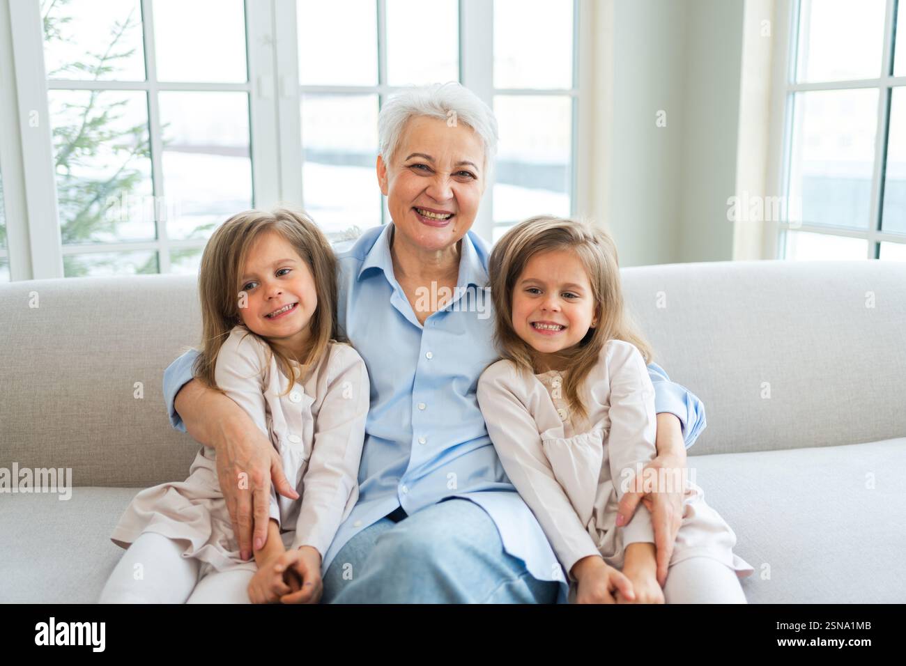 Happy family at home. Two little girls sisters twins grandmother ...