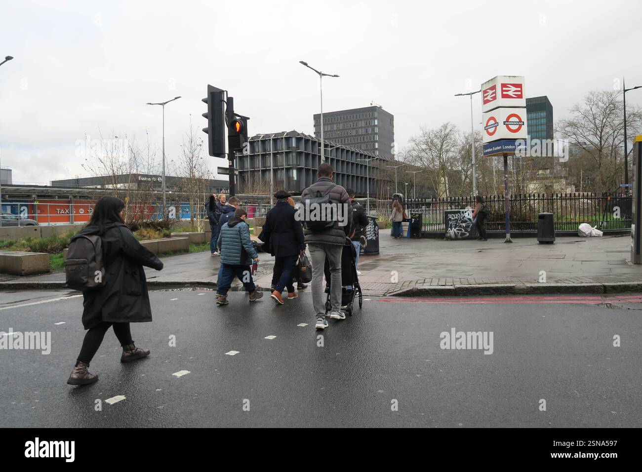 People crossing the road at a pedestrian crossing on their way to ...