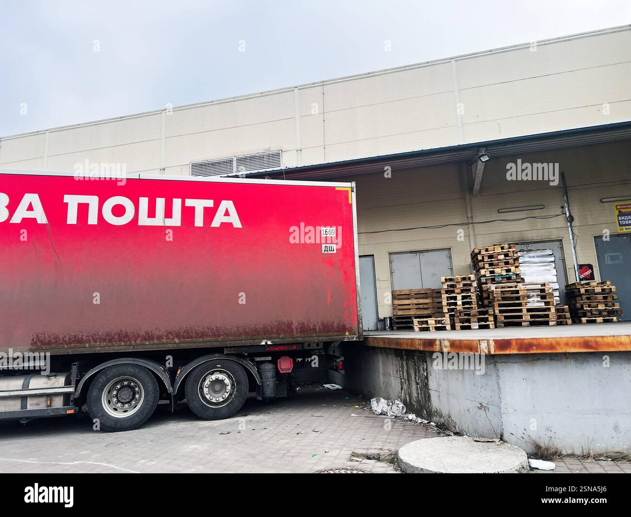 Lviv, Ukraine - February 12, 2025: A red Nova Posta truck parked at an industrial loading dock ...