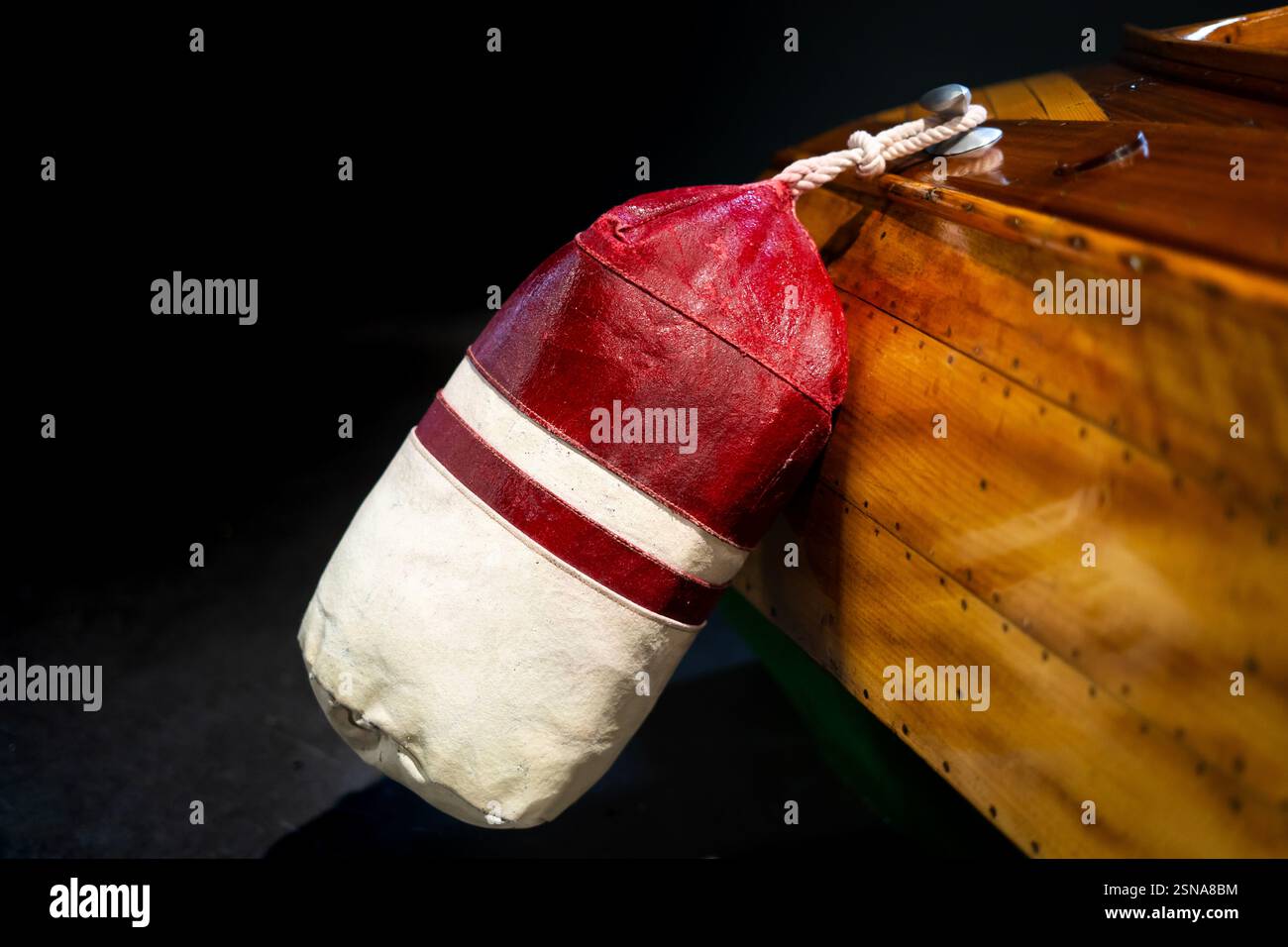 Red white harbor buoy on the side of a classic wooden motorboat with a ...