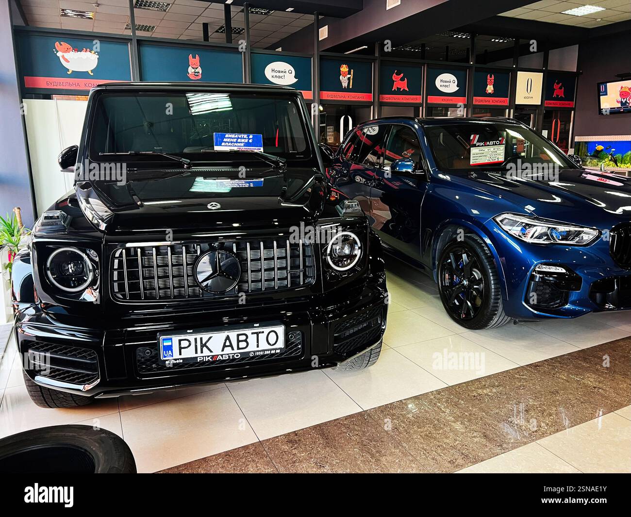 Lviv, Ukraine - February 12, 2025: Two luxury SUVs displayed indoors ...