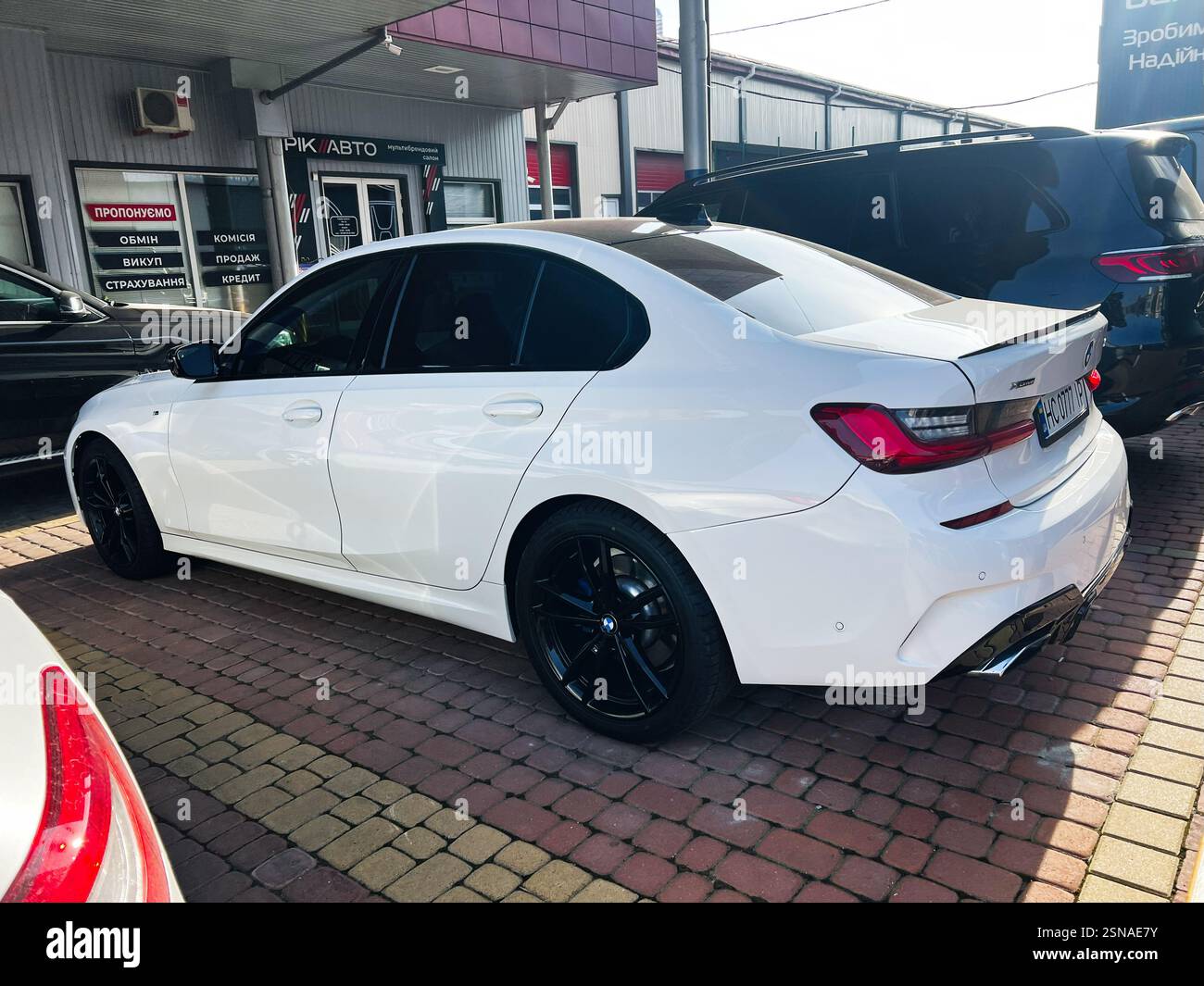 Lviv, Ukraine - February 12, 2025: Luxury white BMW 3 Series sedan parked outside an automotive ...