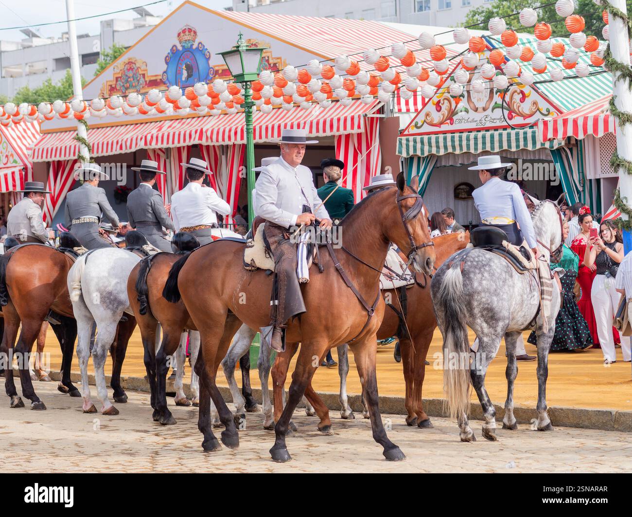 Group of Spanish riders in traditional attire on horseback at an ...