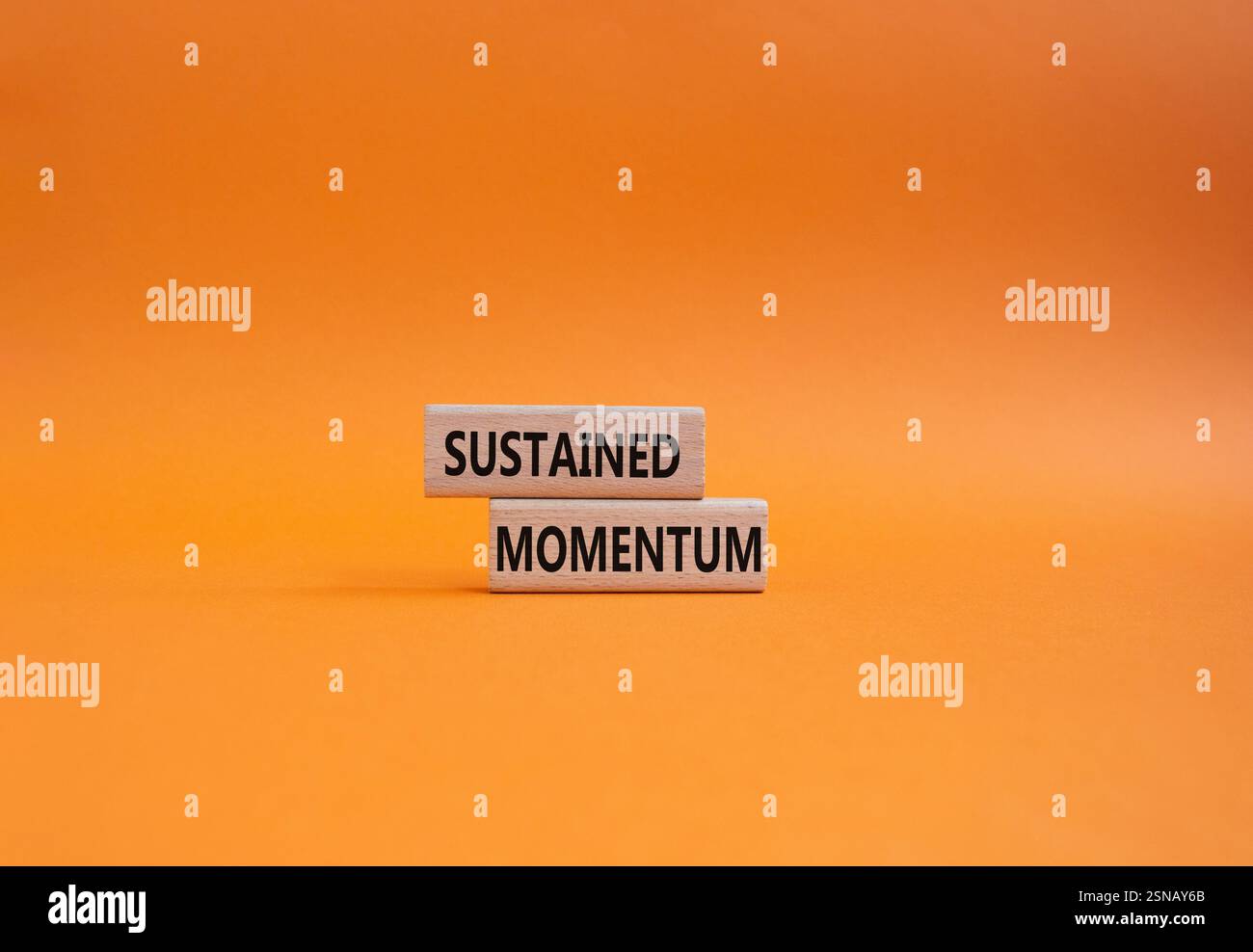 Sustained momentum symbol. Wooden blocks with words Sustained momentum ...