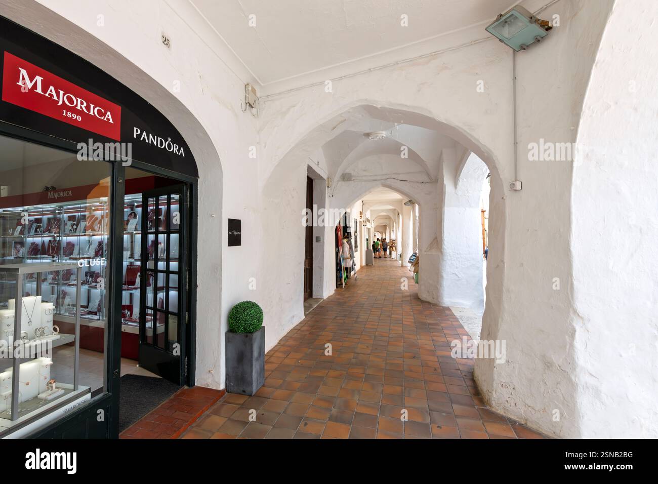 A covered walkway colonnade and arcade with arched whitewashed interior ...