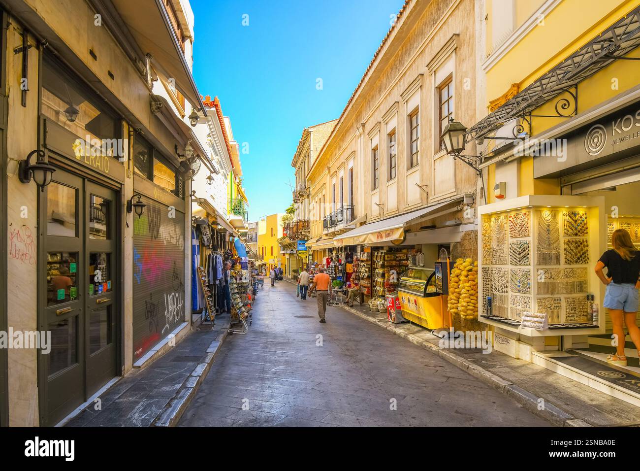 Tourists walk the narrow path between souvenir shops and outdoor ...