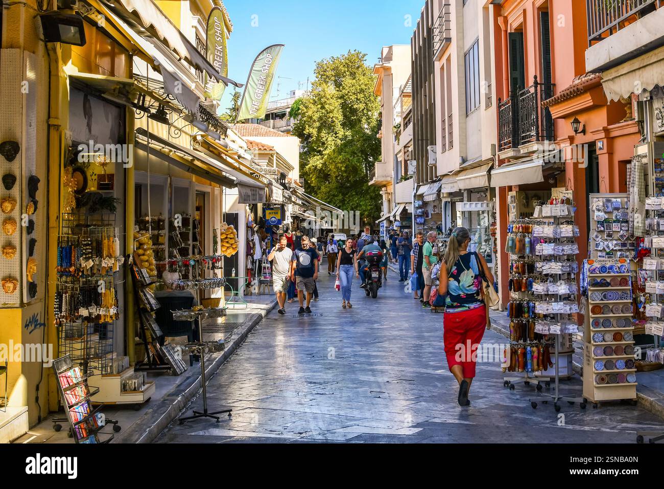Tourists walk the narrow path between souvenir shops and cafes in the ...