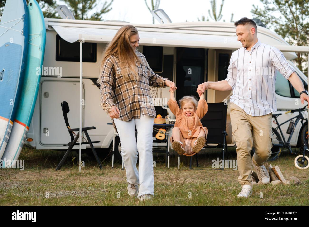 Parents engage in playful activity with their cheerful child near their ...