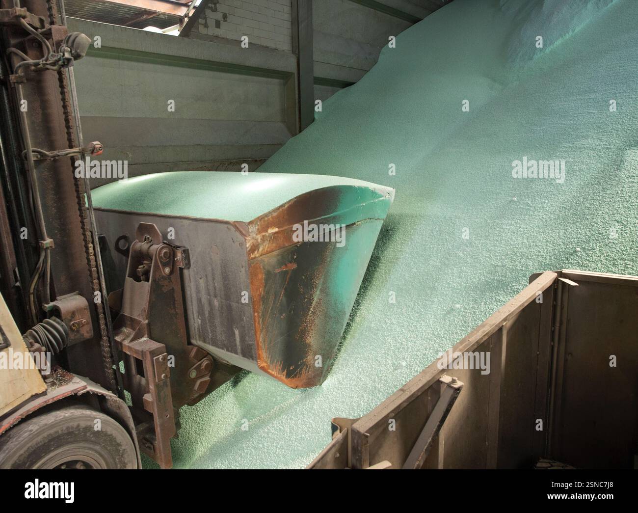 Shovel dumping fertilizer in a silo. At a distribution and storage ...