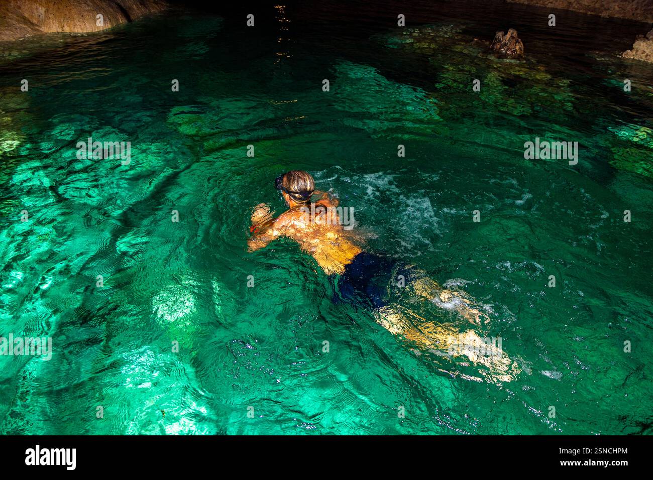 Man male tour guide is swimming and snorkeling in the turquoise green ...