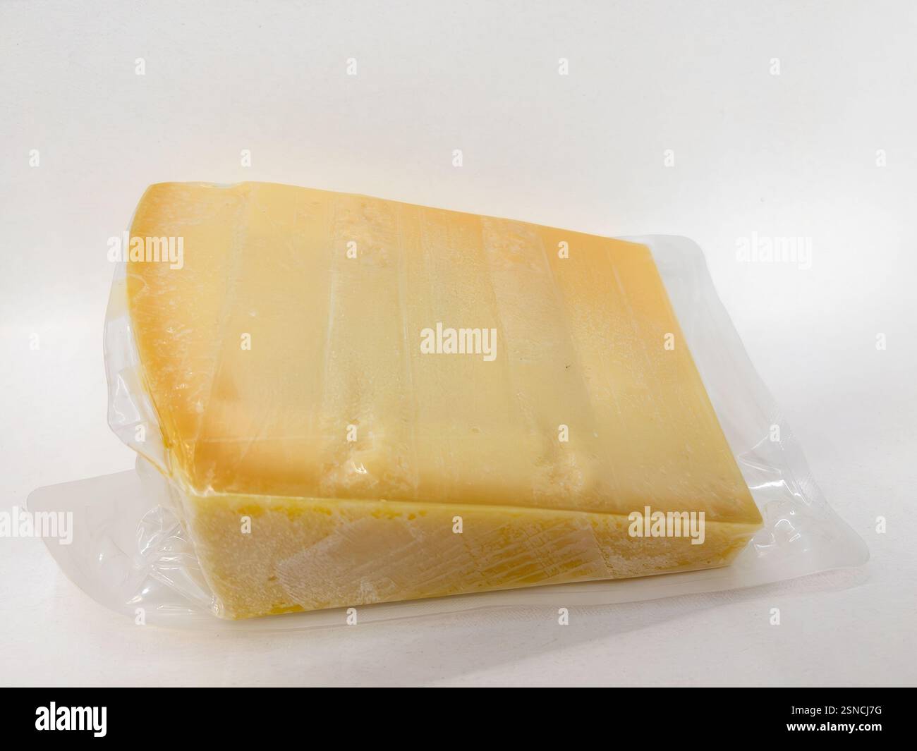 Slice of parmesan cheese vacuum sealed in plastic bag on white back ...