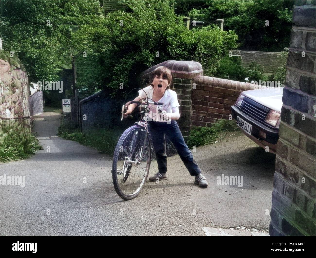 Child pushing bicycle up steep hill Stock Photo - Alamy