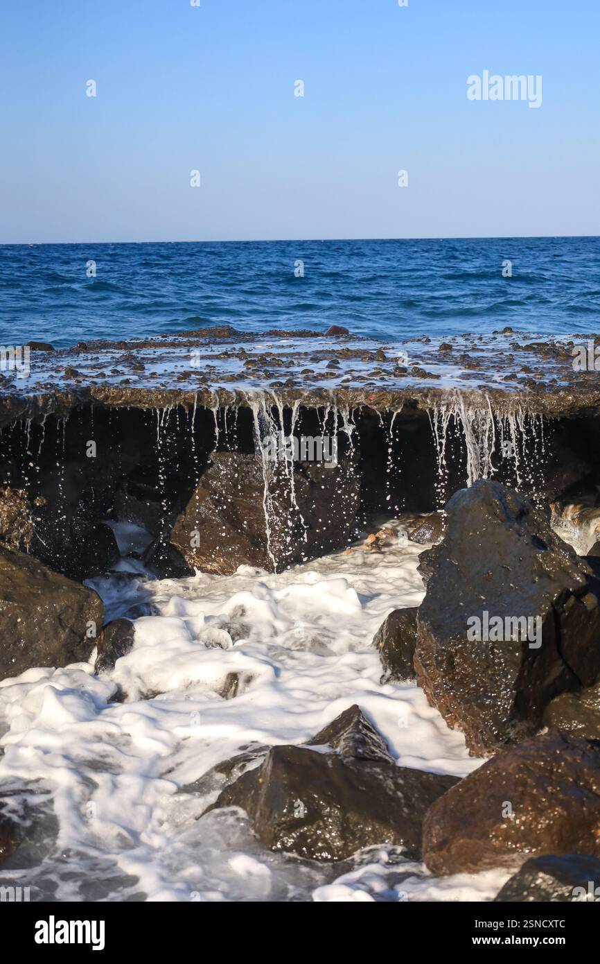 close-up of ocean waves forcefully hitting a rocky seawall, creating ...