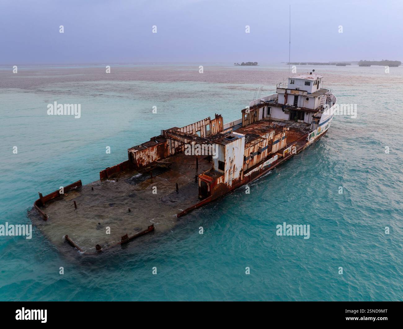 Aerial view of a half sunken ship at Maldives, Indian ocean. Big rusty ...