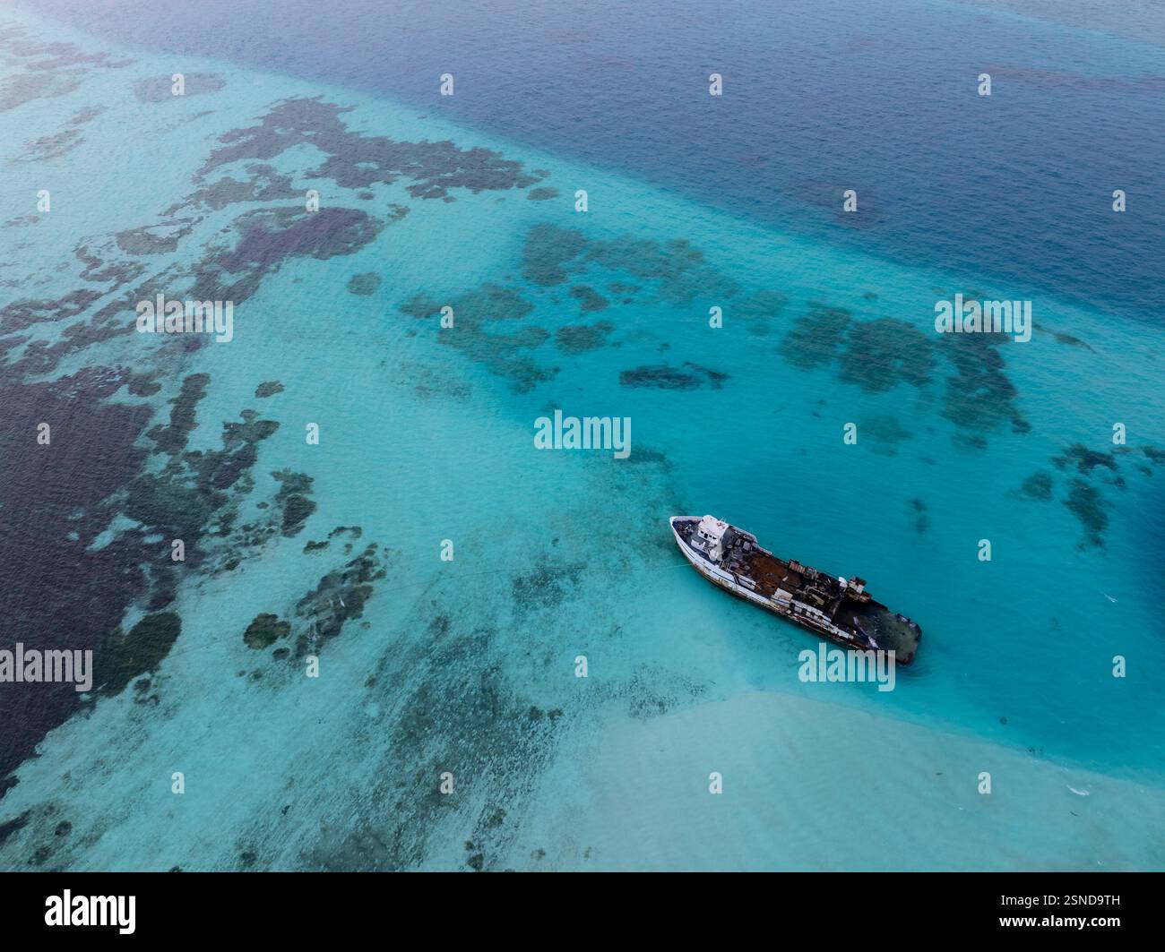 Aerial view of a half sunken ship at Maldives, Indian ocean. Big rusty ...
