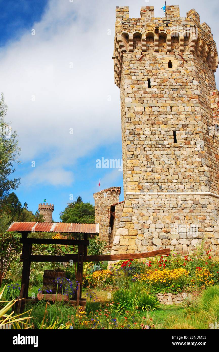 A stone replica of a medieval castle is surrounded by a rustic well and ...