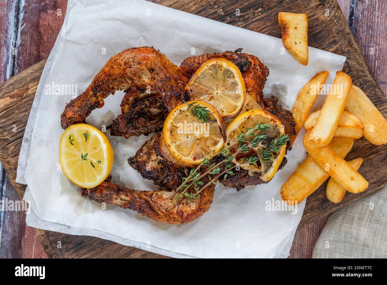 Roasted spatchcock poussin with potato chips Stock Photo - Alamy