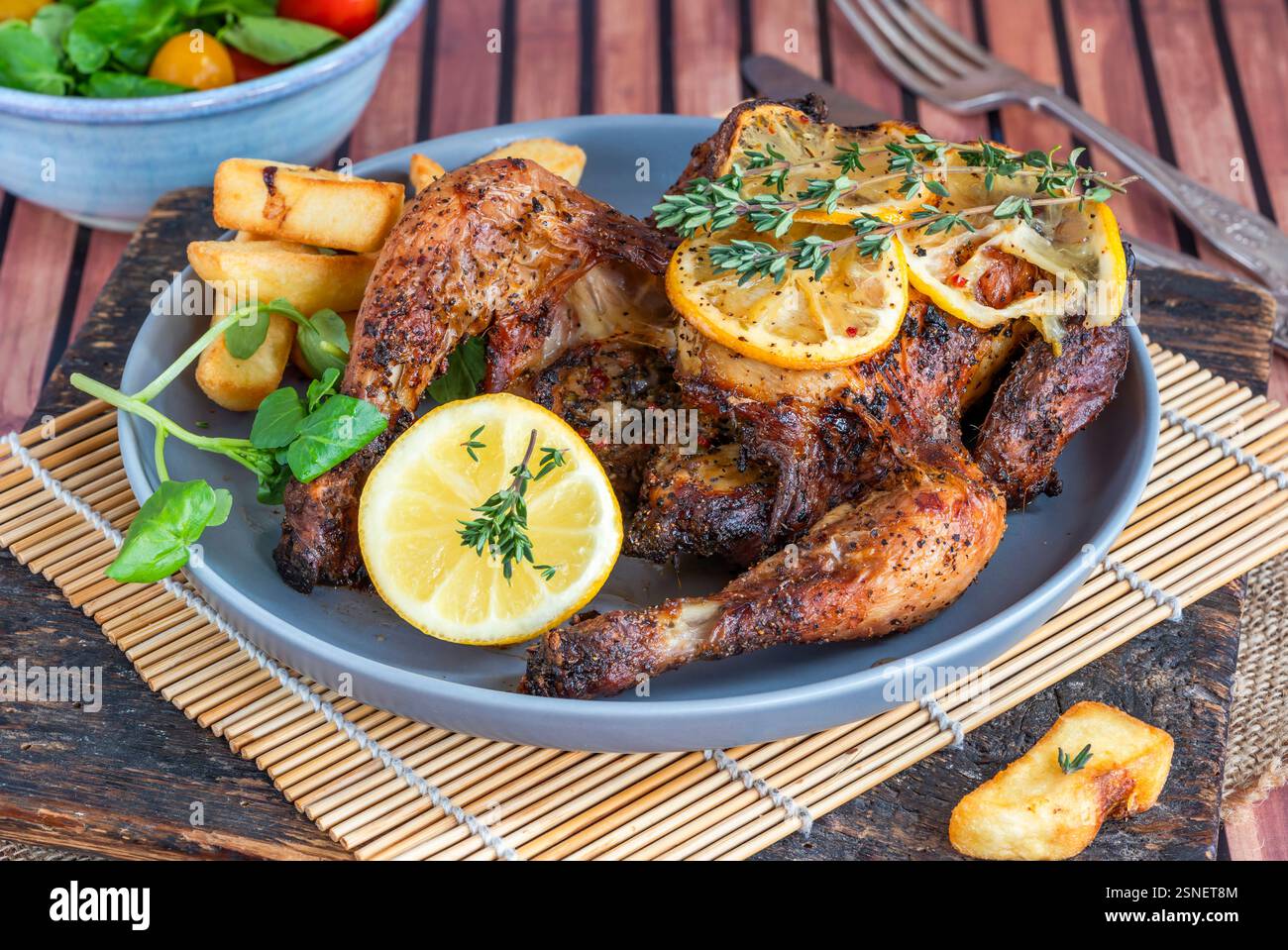Roasted spatchcock poussin with potato chips Stock Photo - Alamy