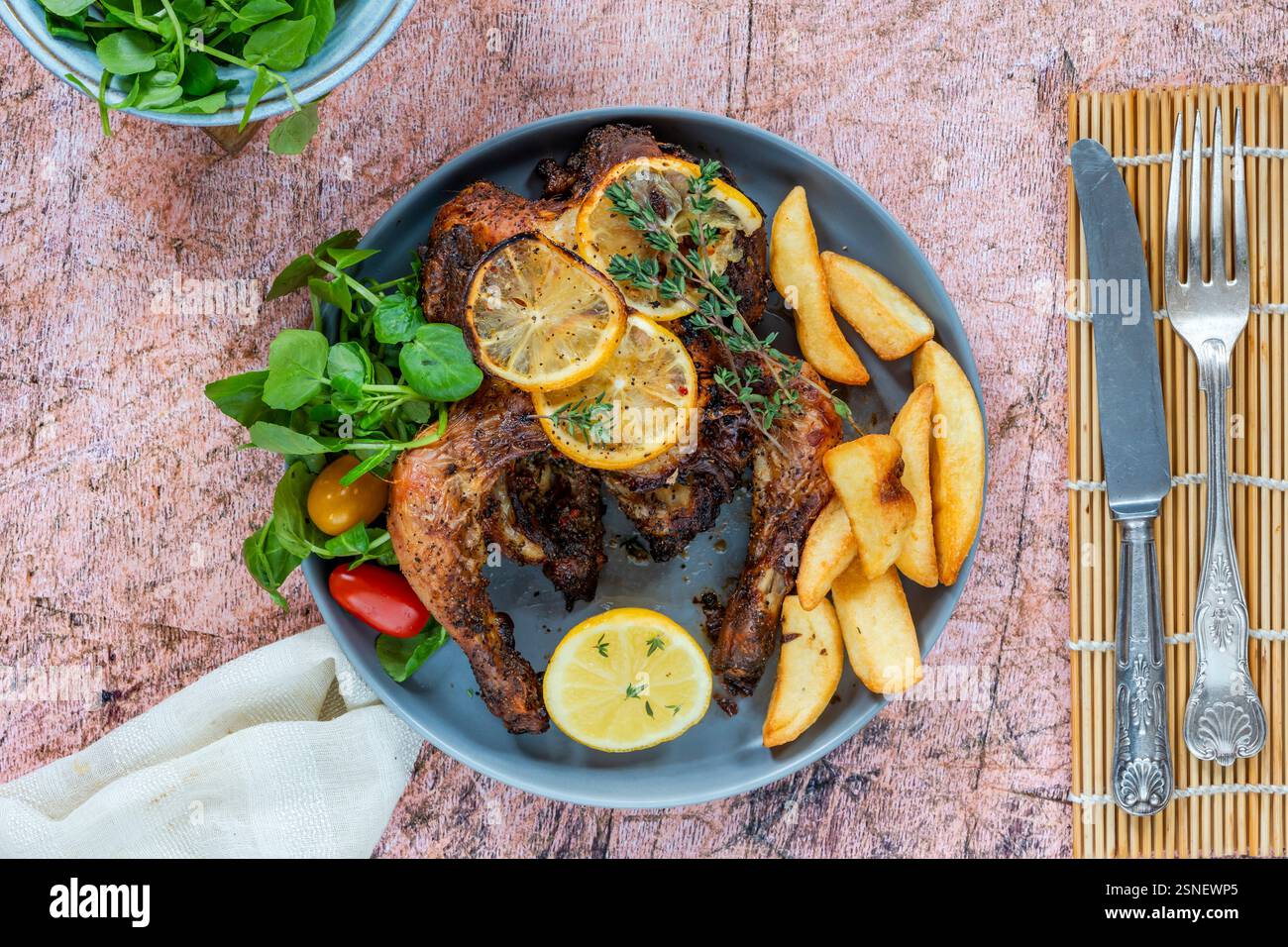 Roasted spatchcock poussin with potato chips Stock Photo - Alamy
