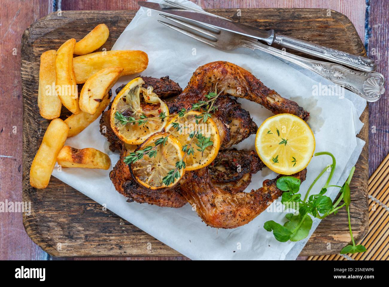 Roasted spatchcock poussin with potato chips Stock Photo - Alamy
