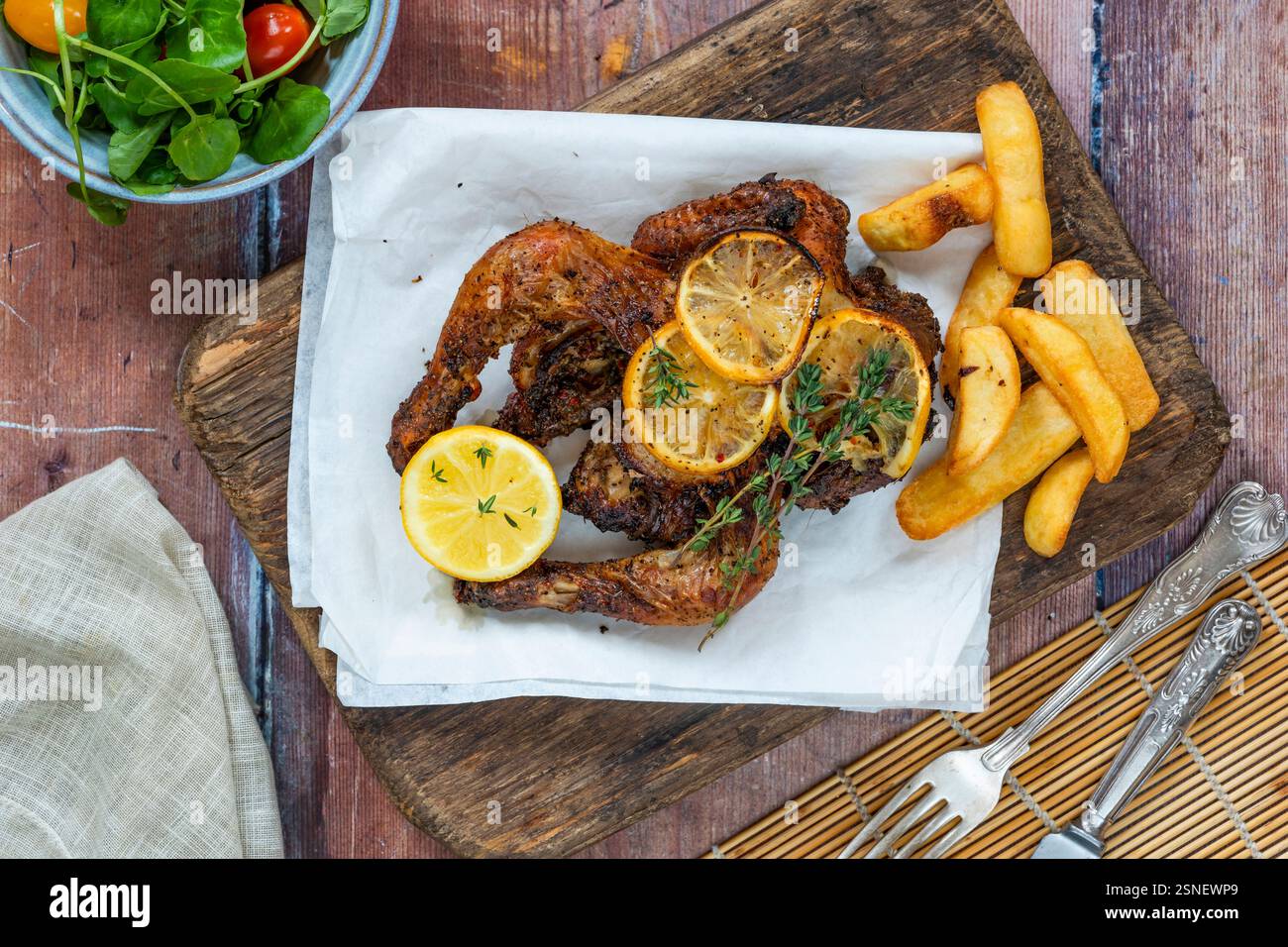 Roasted spatchcock poussin with potato chips Stock Photo - Alamy