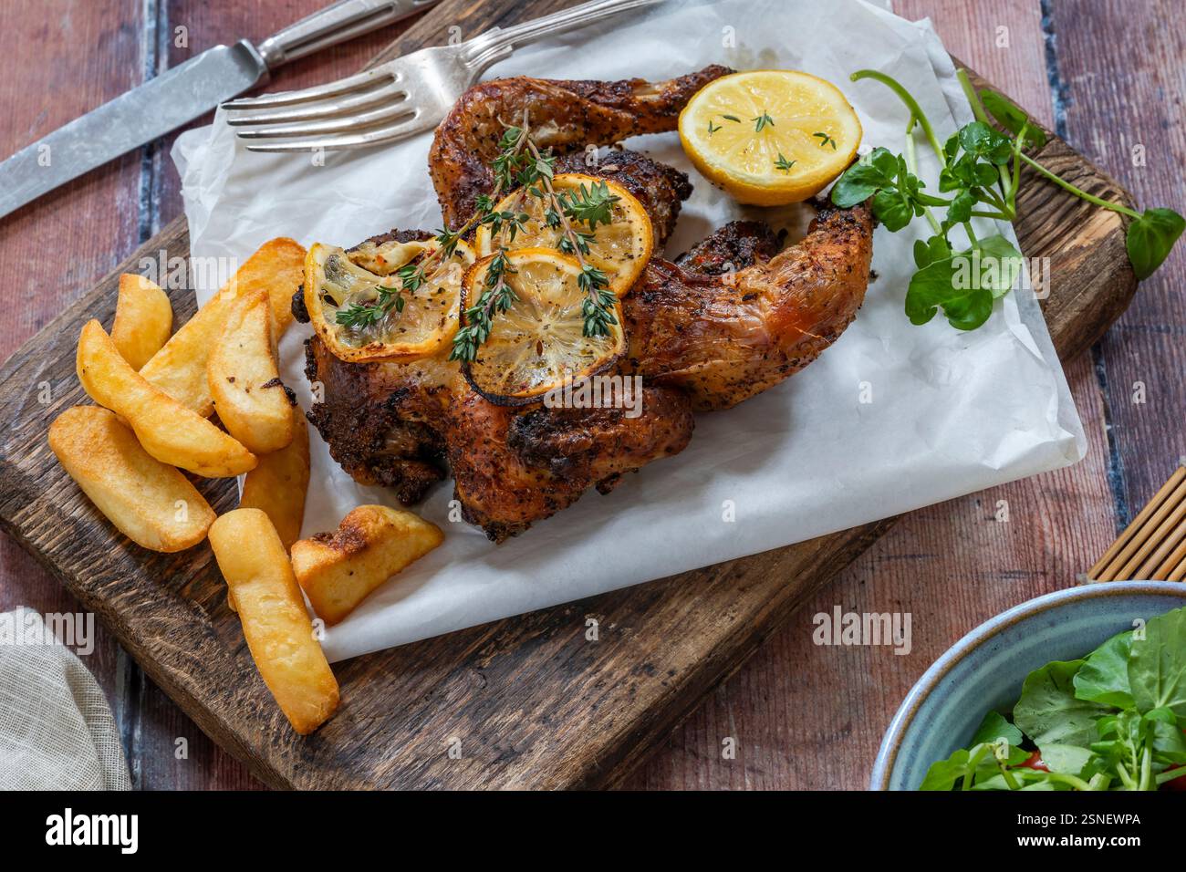 Roasted spatchcock poussin with potato chips Stock Photo - Alamy