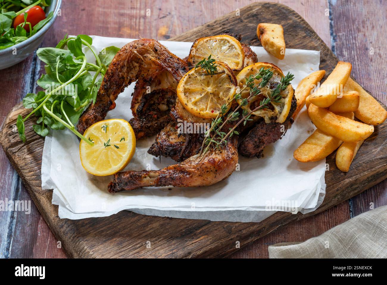 Roasted spatchcock poussin with potato chips Stock Photo - Alamy