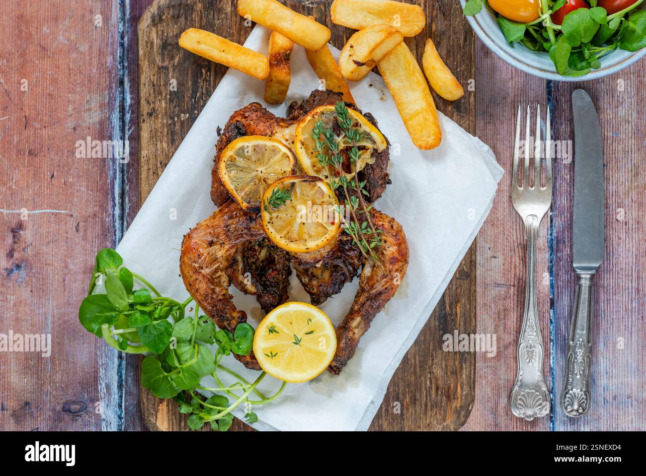 Roasted spatchcock poussin with potato chips Stock Photo - Alamy