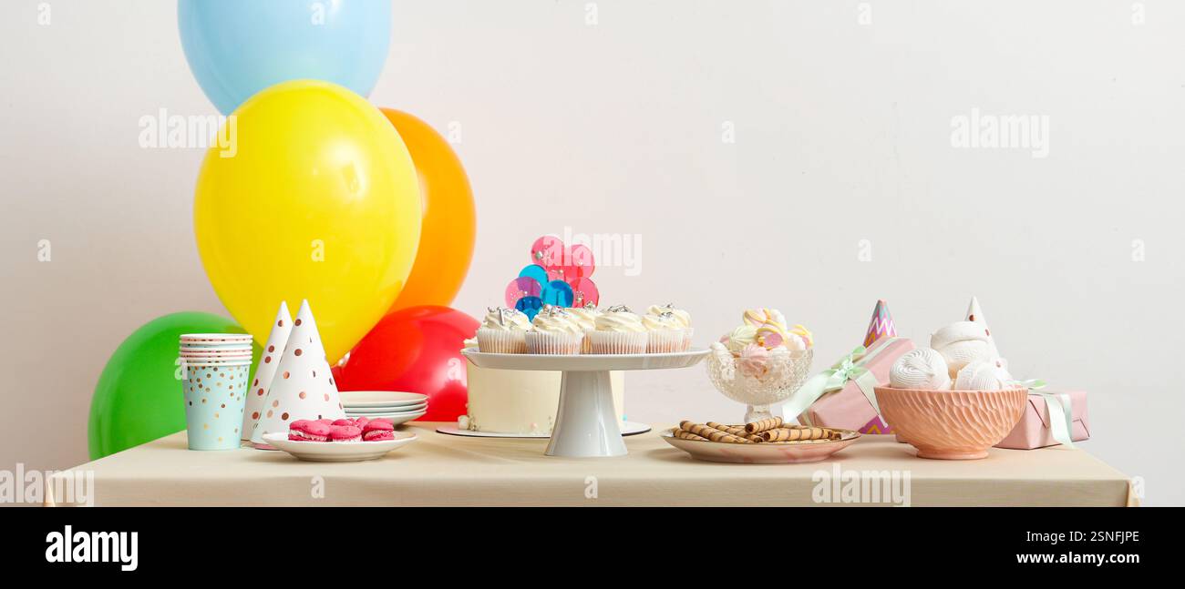 Table with different desserts and balloons for birthday party Stock ...