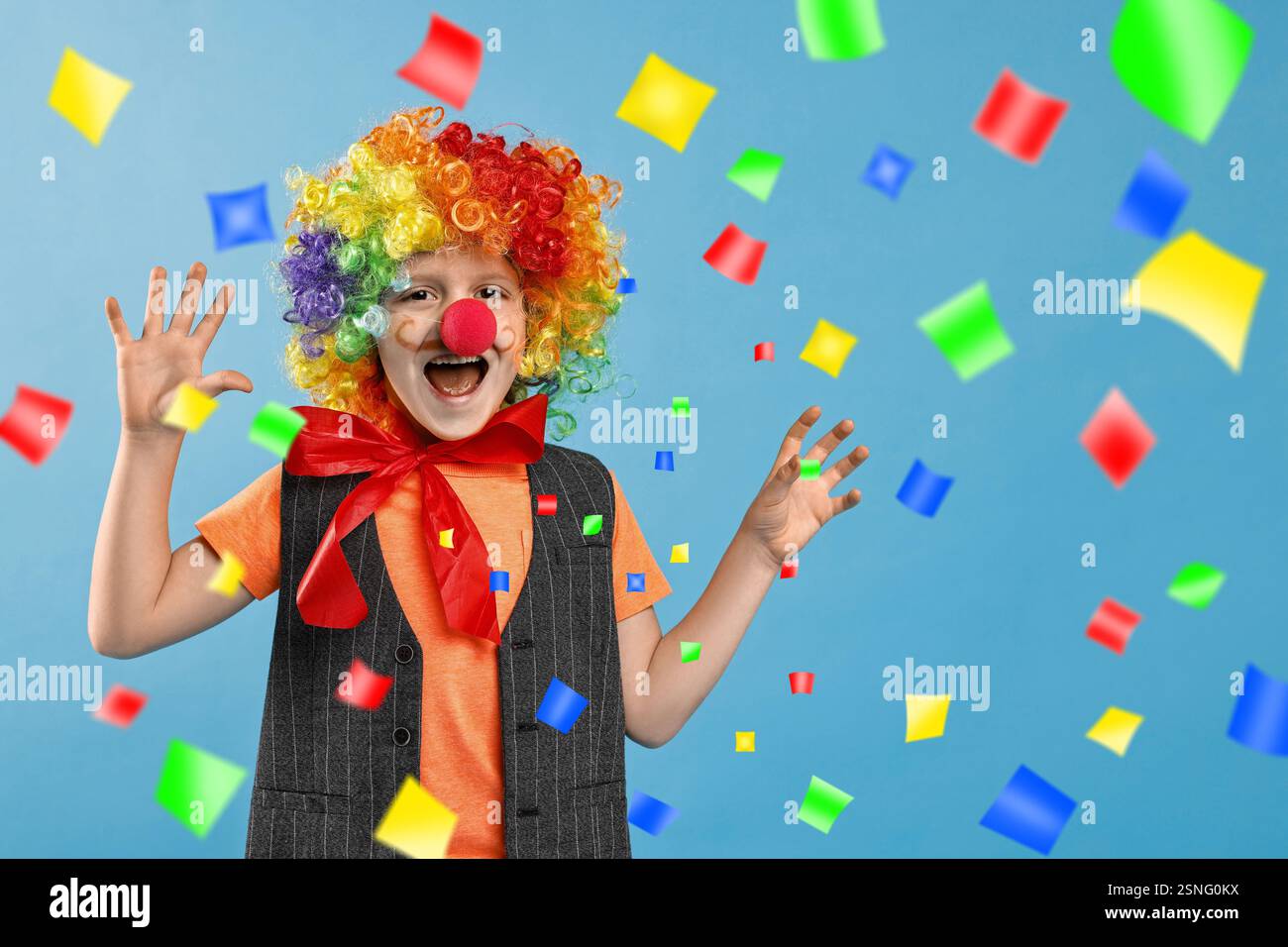 Happy boy dressed like clown under falling confetti on light blue ...
