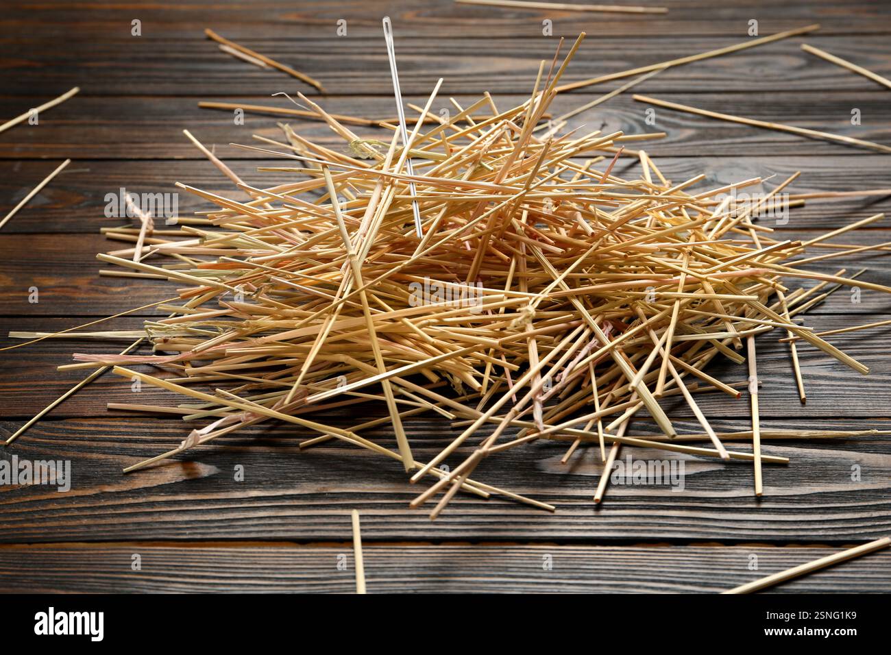 Sewing needle in haystack on wooden background, closeup view Stock ...