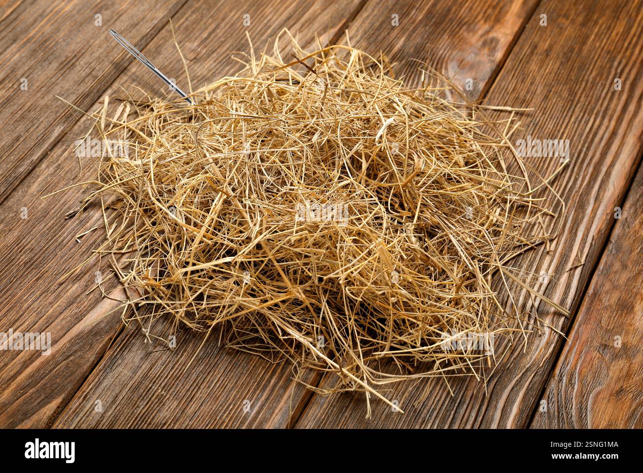 Sewing needle in haystack on wooden background, closeup view Stock ...