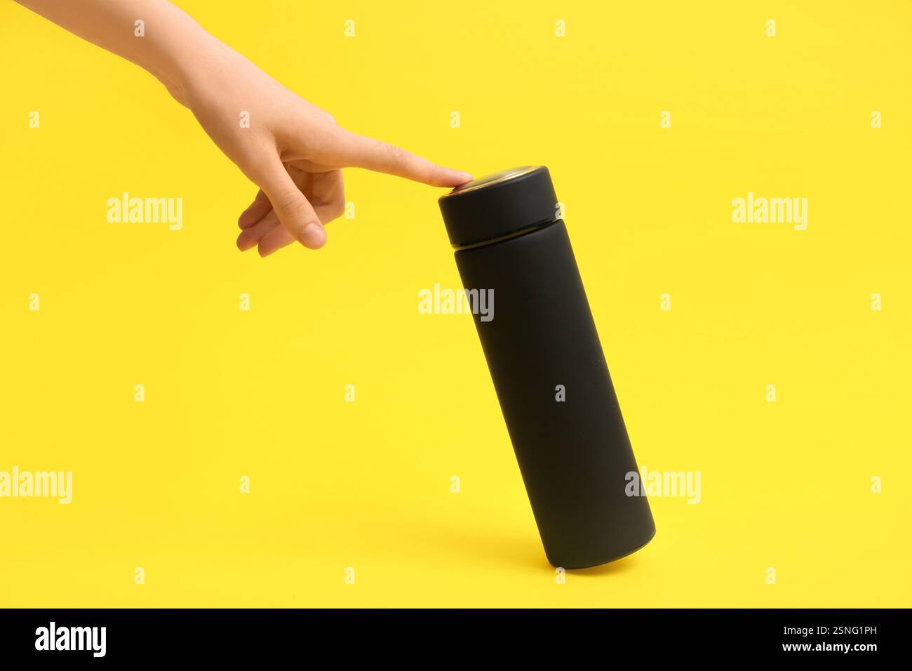 Female hand with modern black thermos on yellow background Stock Photo ...