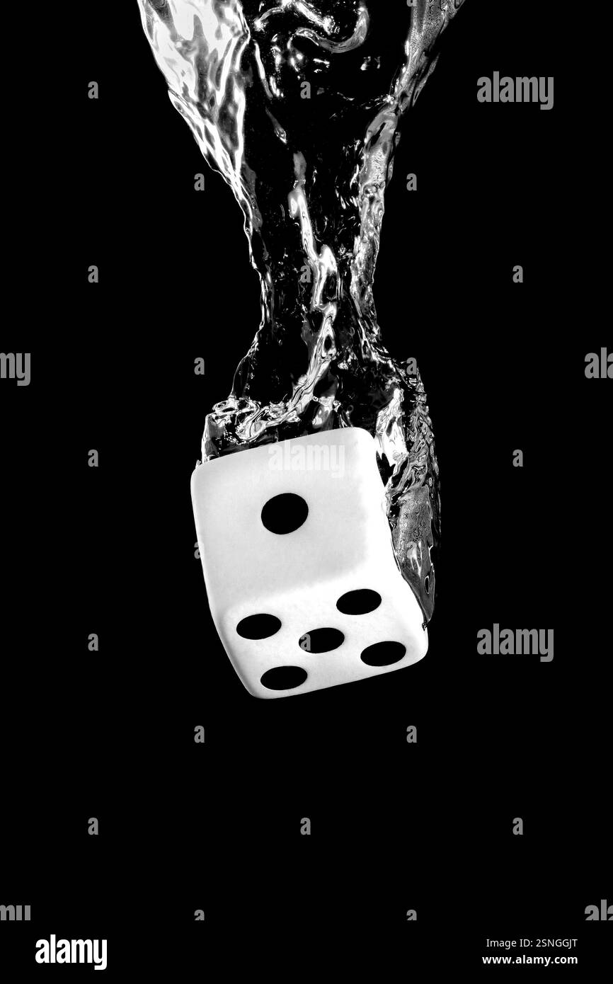 Monochrome photo of a dice as it descent in water with dark background ...