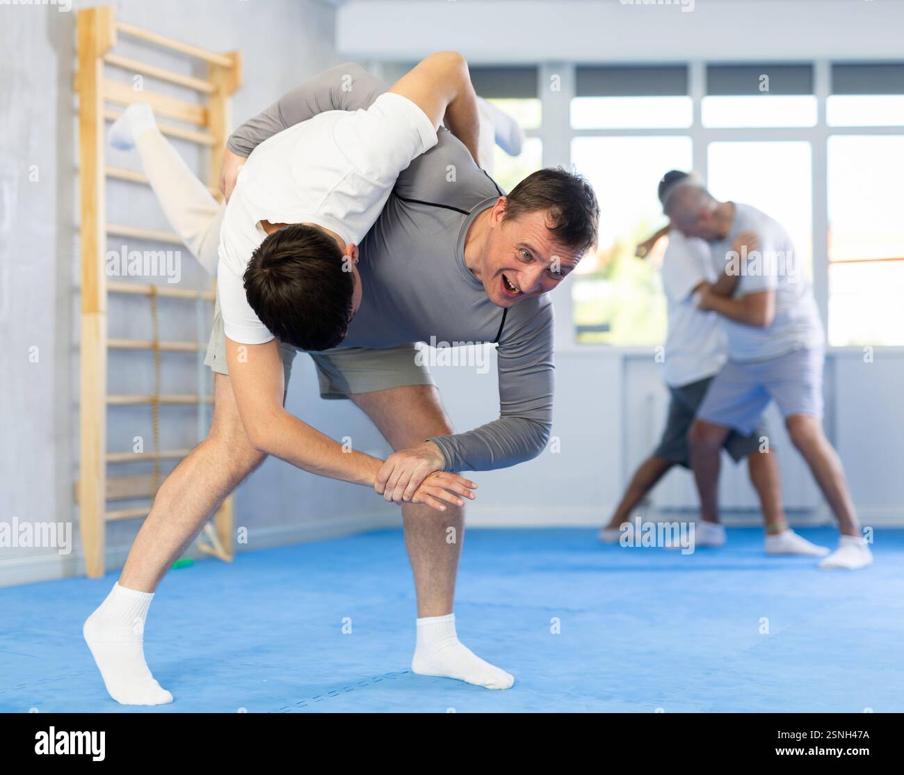 Young guy and man practice wrestling, apply techniques of Aikido and ...