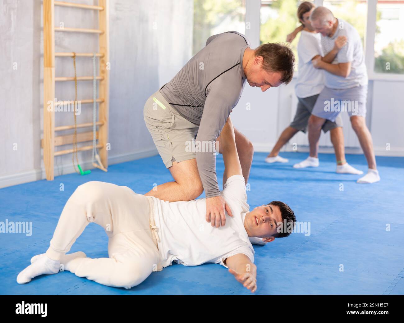 Guy and man are training in gym practicing technique of grabbing arm ...
