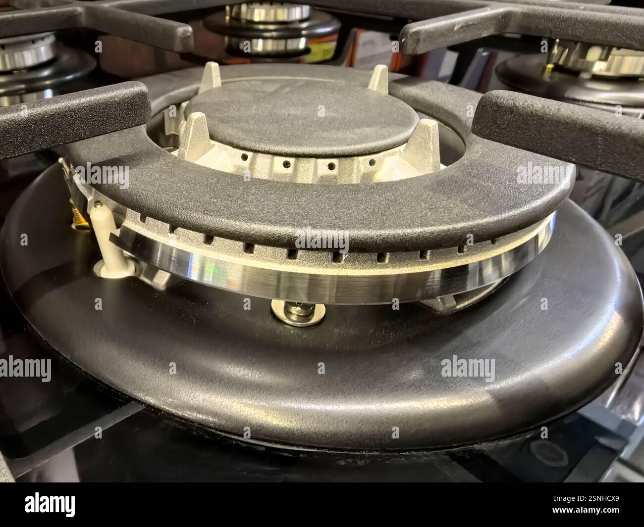 A detailed view of a gas stove burner showcases its complex design ...