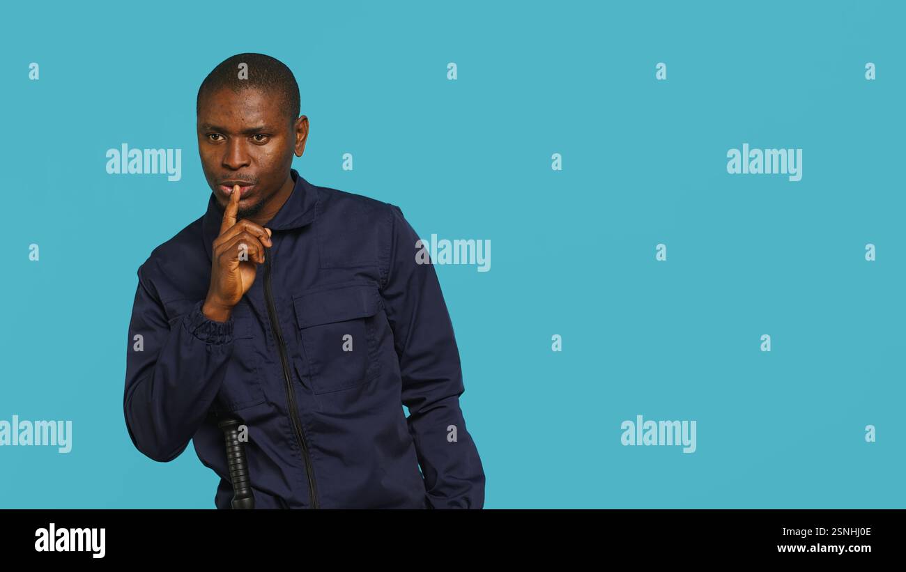 Portrait of security guard doing shush sign gesturing with finger to ...