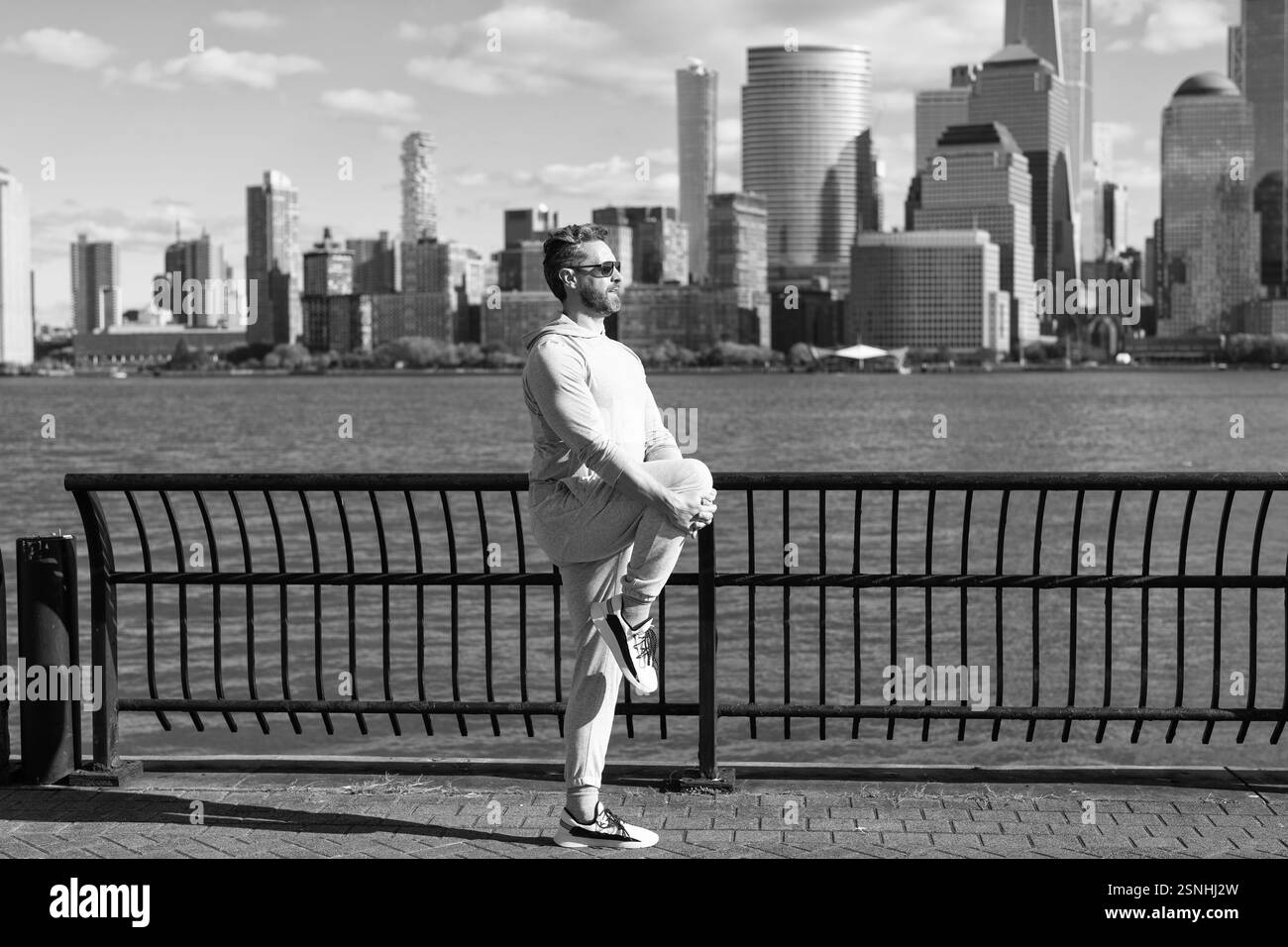 Stretching routine of sportsman outdoor in NY. Sportsman stretching his ...