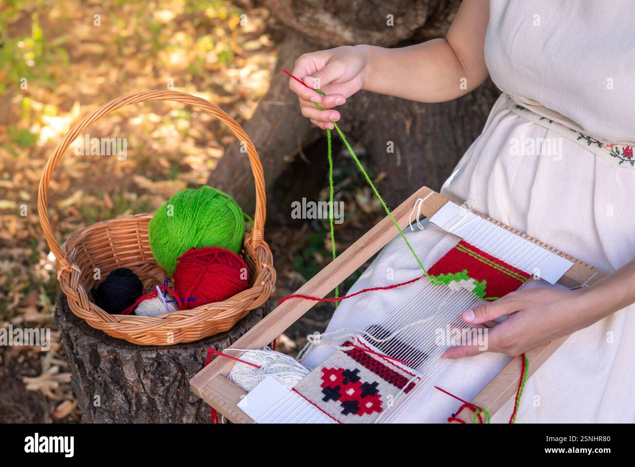 Woman weaver's hands using a weaving needle on a hand loom. Selective ...