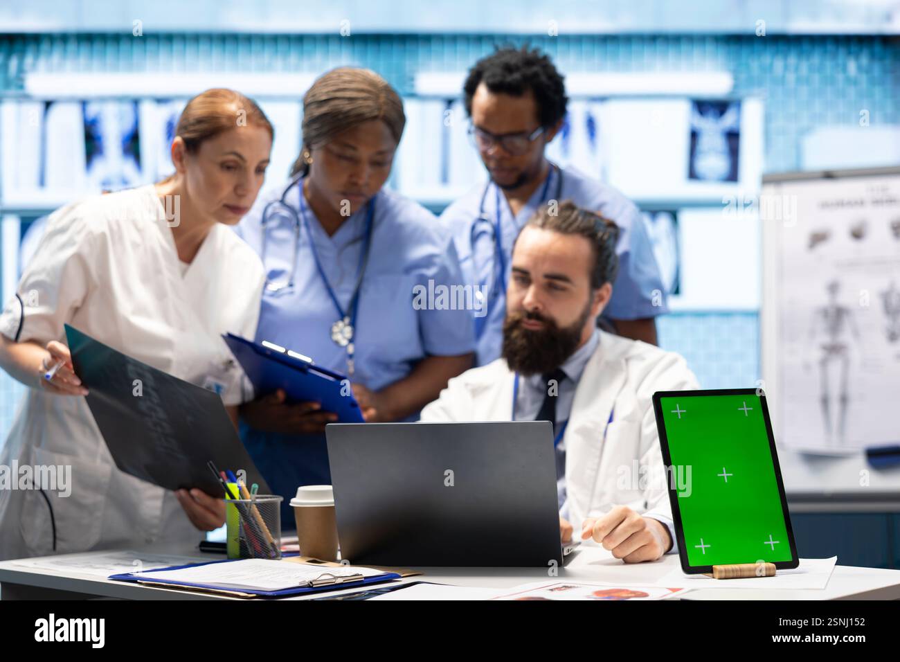 Group of doctors consulting hospital records next to chroma key display ...