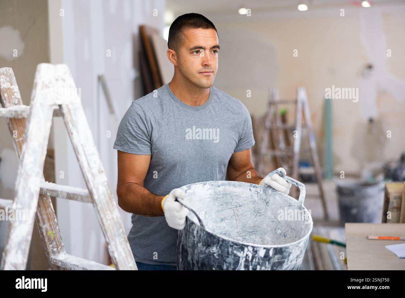 Man carrying bucket while working in apartment, repair works Stock ...