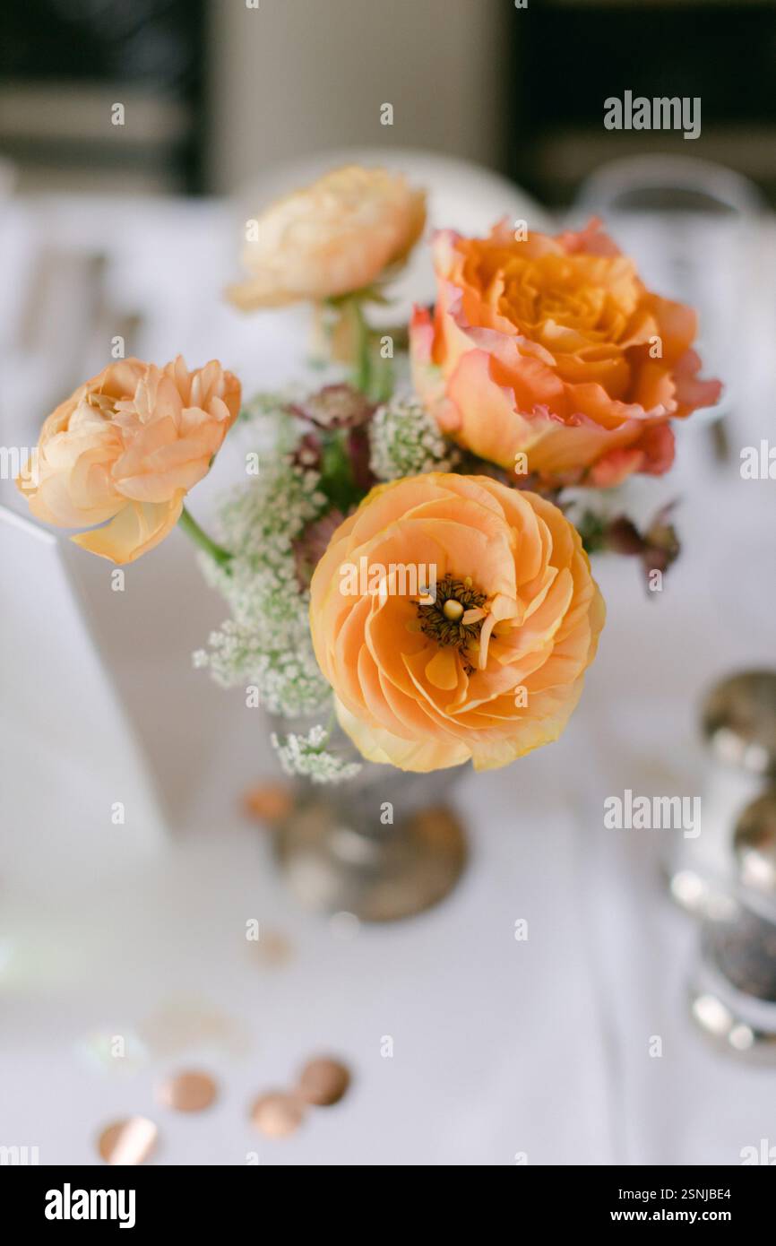 Vibrant orange roses and delicate accents create a beautiful table ...
